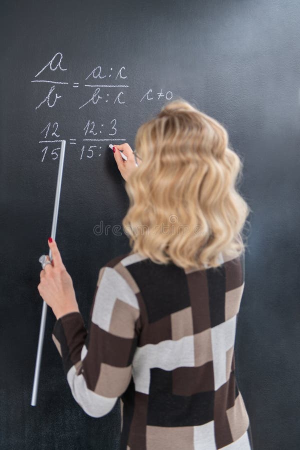 Young Female Math Teacher Explaining Fractions on the Blackboard Stock ...