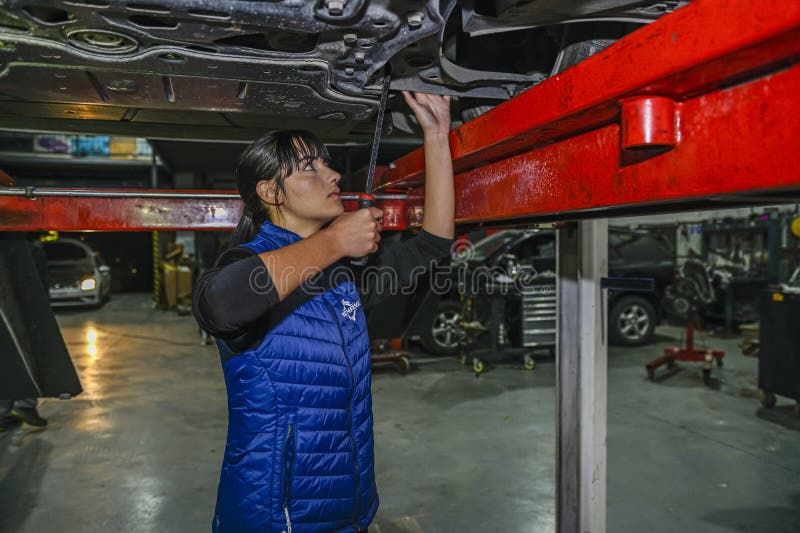 Young Female Mechanic, Working on the Repair of a Car Engine. Stock ...