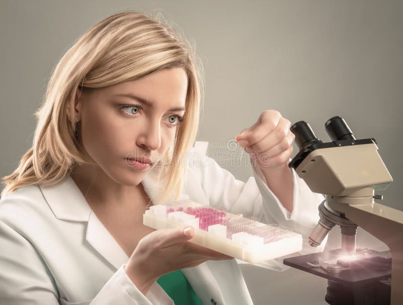 Young Female Microscopist in White Coat Selects a Tissue Sample Stock ...