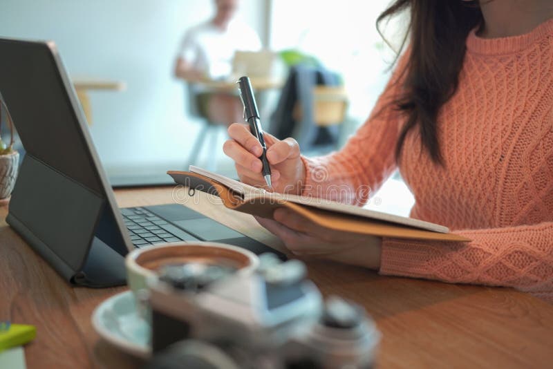 Female in Pink Sweater Using Computer Table and Making Notes on ...
