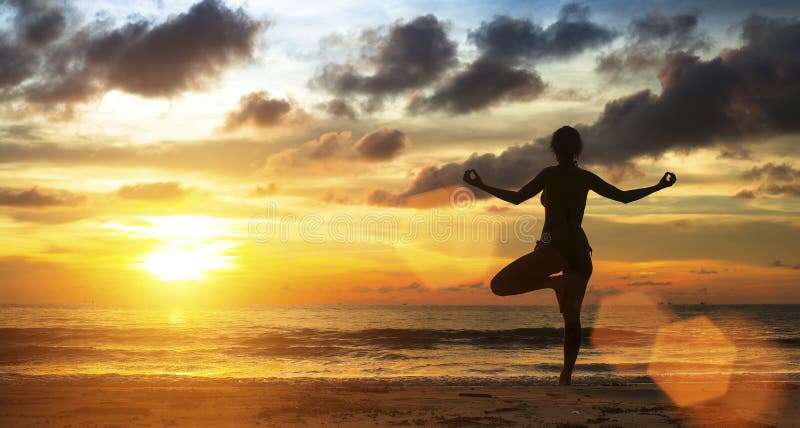 Young Female Practicing Yoga on the Sea Beach at Sunset. Stock Image ...