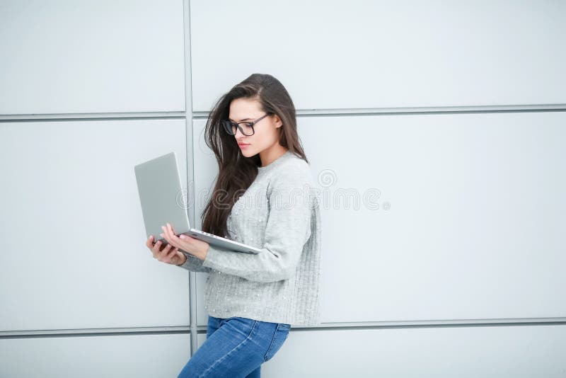 A Young Female Programmer Stands With A Laptop In Her Hands On A ... A Young Female Programmer Stands With A Laptop In Her Hands On A ...