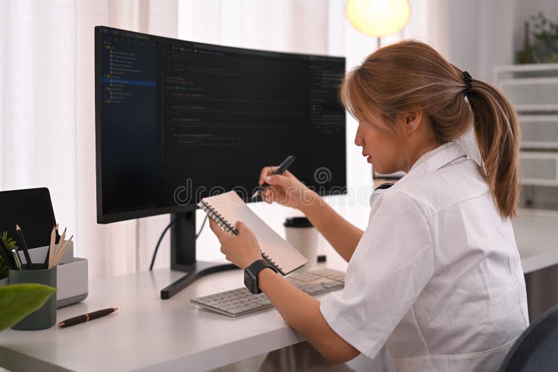 Young Female Programmer Working with Coded Data on Desktop Computer in ... Young Female Programmer Working with Coded Data on Desktop Computer in ...