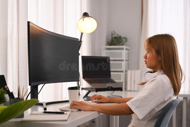 Young Female Programmer Working with Coded Data on Desktop Computer in ... Young Female Programmer Working with Coded Data on Desktop Computer in ...