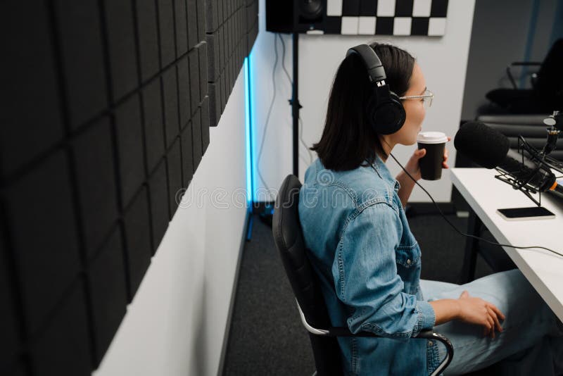 Young Female Radio Host Using Microphone and Headphones in Studio Stock ...