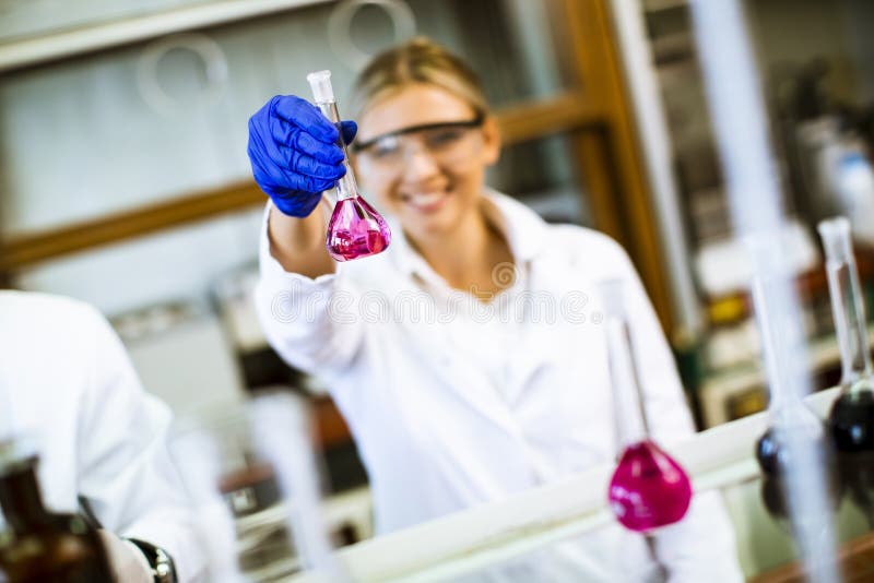 Young Female Scientist Examining Liquid in Biochemical Lab Stock Photo ... Young Female Scientist Examining Liquid in Biochemical Lab Stock Photo ...
