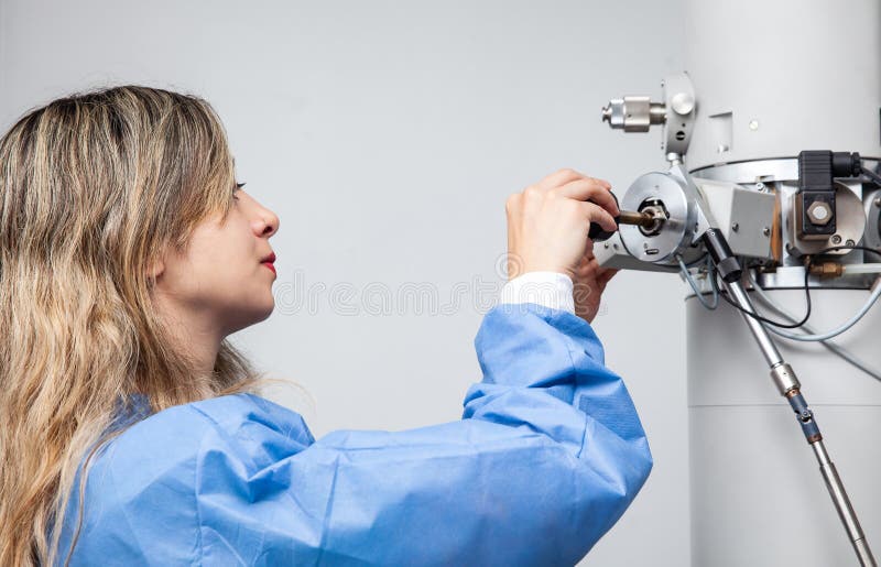 Young Female Scientist Loading a Specimen Using a Sample Holder into a ...