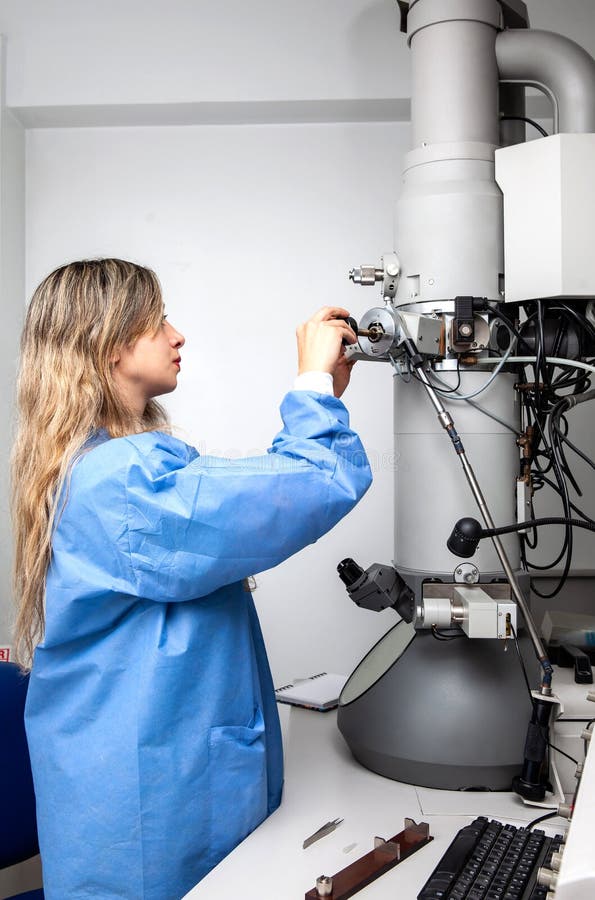 Young Female Scientist Loading a Specimen Using a Sample Holder into a ...