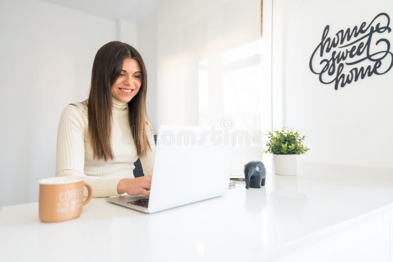 Young Female Sitting at a Desk in a Well-lit Environment, Working on ...