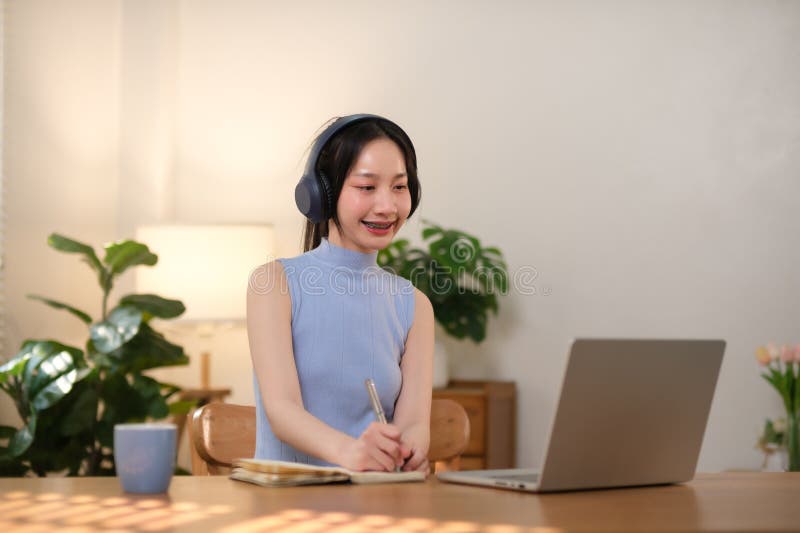 A Young Female Student is Sitting at the Desk in the Workspace and ...
