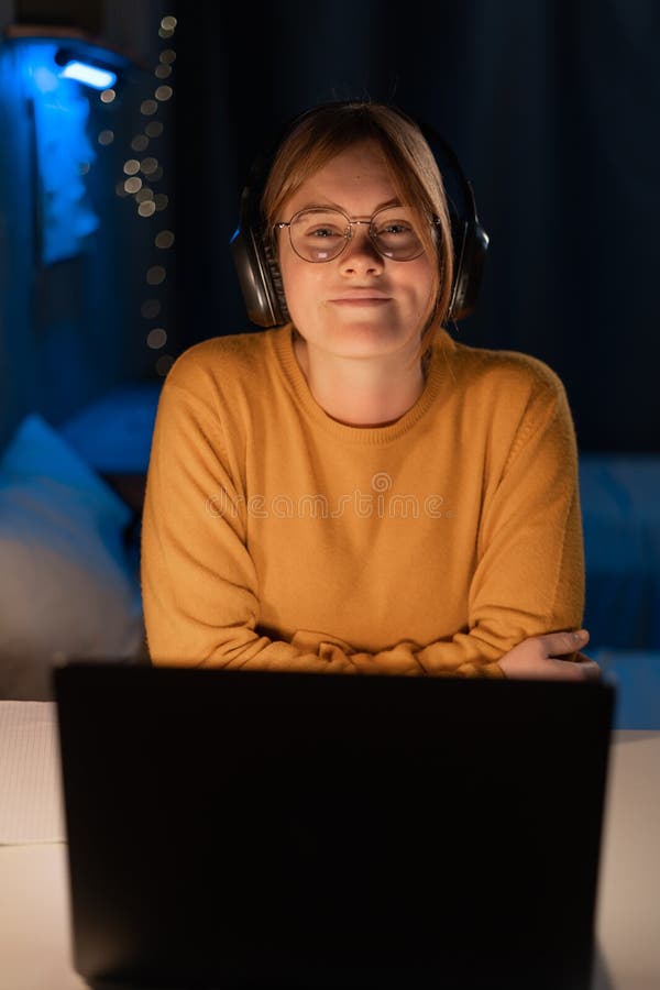 Young Female Student Sitting at the Table, Using Headphones when ...