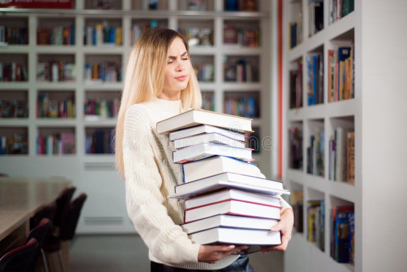 Young Female Student Study in the School Library with a Many Books in ...