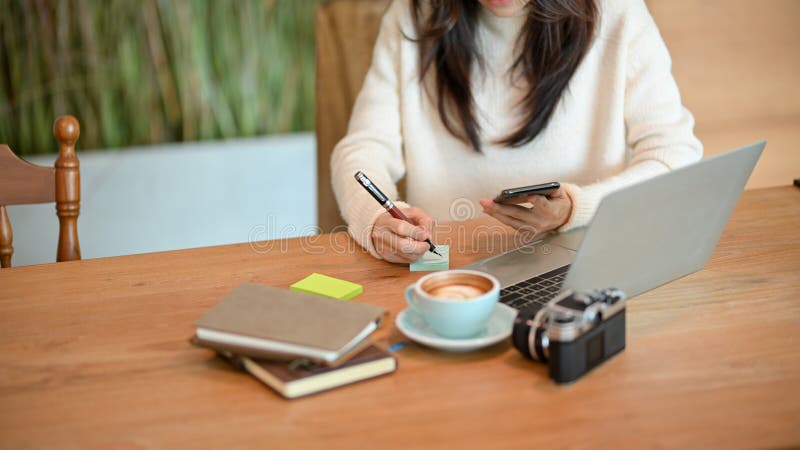Young Female Taking Notes on a Sticky Colourful Notepaper while Looking ...
