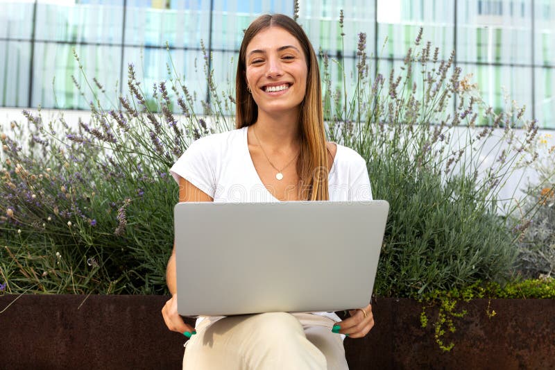 Young Female University Student Sitting on Bench Using Laptop Looking ...