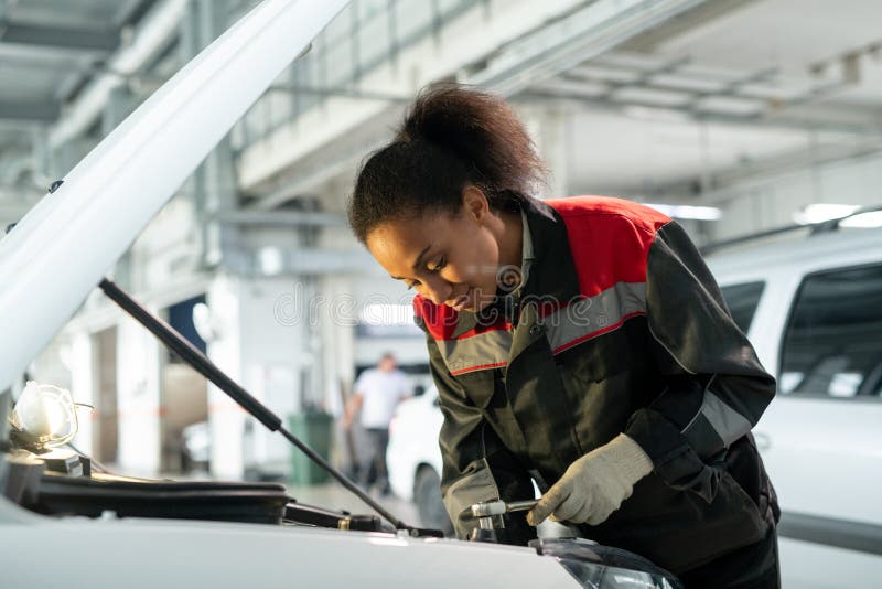 Young Female Worker of Car Repair Service Bending Over Open Engine ...