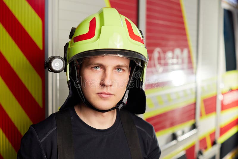 Young Fireman in Uniform Standing in Front of Firetruck, he is Ready ...