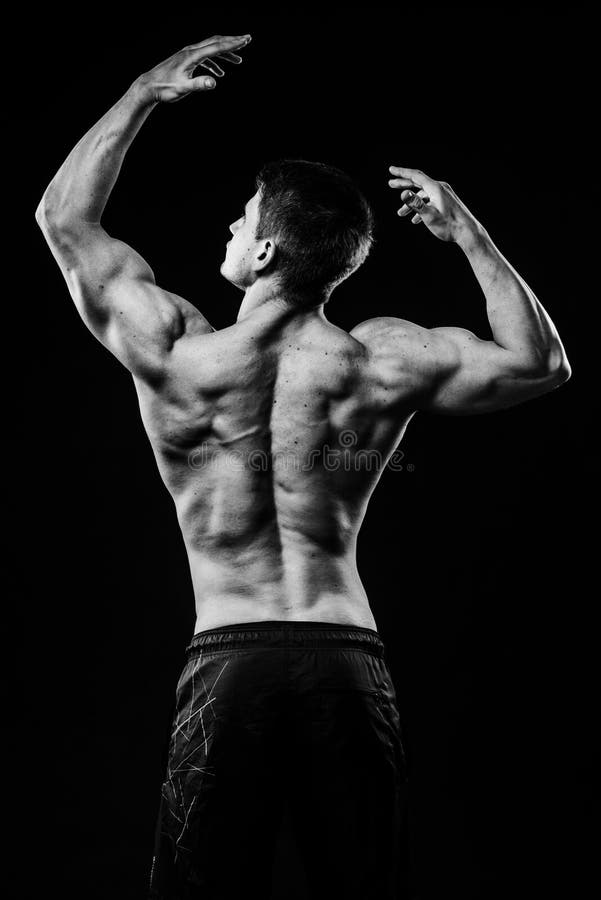 Young and Fit Bodybuilder Athlete Demonstrates Biceps Back View on ...