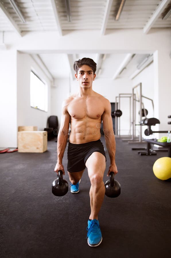 Young Fit Hispanic Man in Gym Doing Lunges with Kettlebells Stock Photo ...