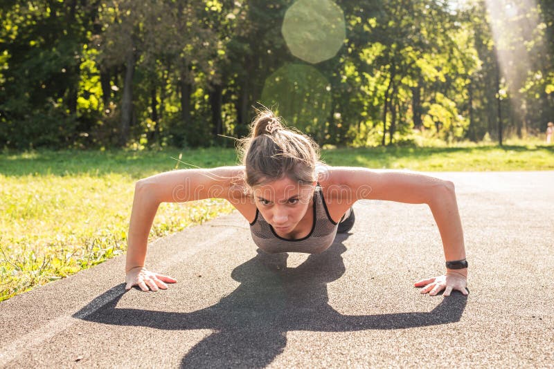 Young Fit Woman Exercising by Doing Push-ups Outdoors Stock Image ...