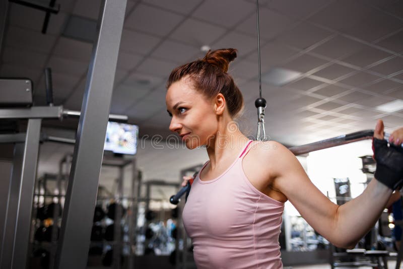Young Woman on Pulls Down Cable Machine in Gym Stock Photo - Image of ...