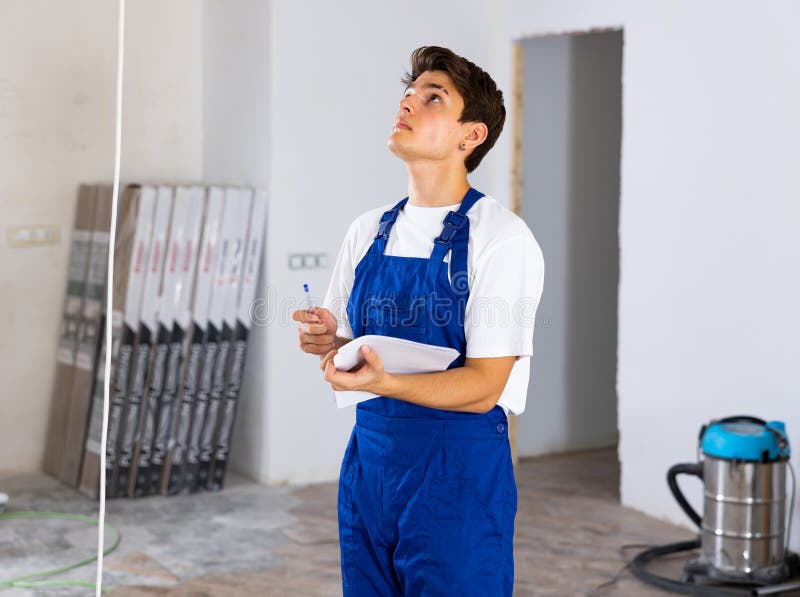 Young Foreman Making Task List during Works in Building Under ...