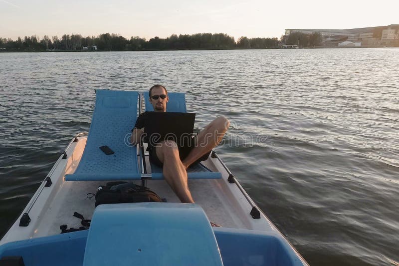 Young Freelancer Works on the Computer on a Boat. Remote Business ...
