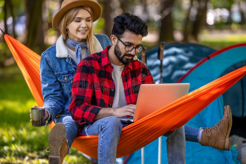 Young Freelancer Working on Laptop in the Forest, with His Girlfriend ...