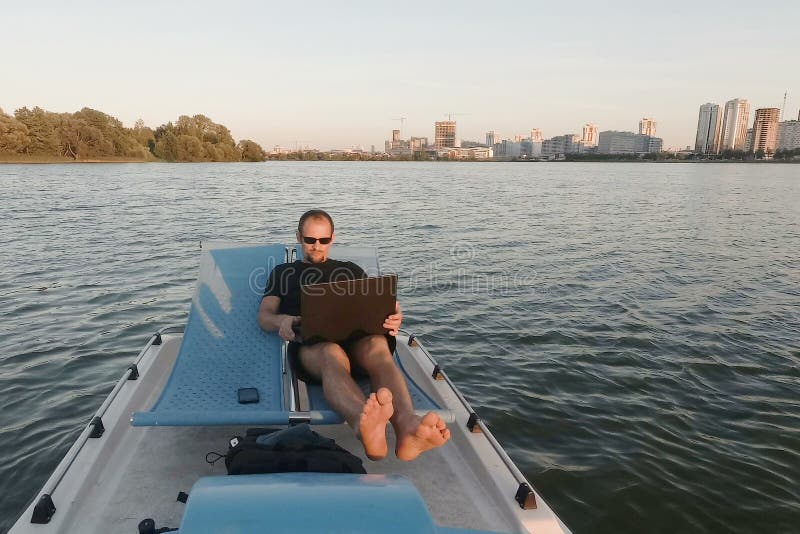 Young Freelancer Works on the Computer on a Boat. Remote Business ...