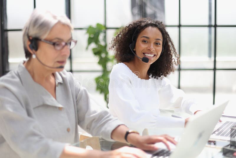 Young Friendly Operator Woman Agent with Headsets Working in a Call ...