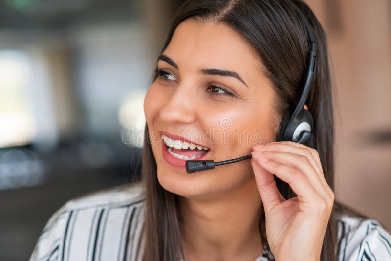 Young Friendly Operator Woman Agent with Headsets Working in a Call ...