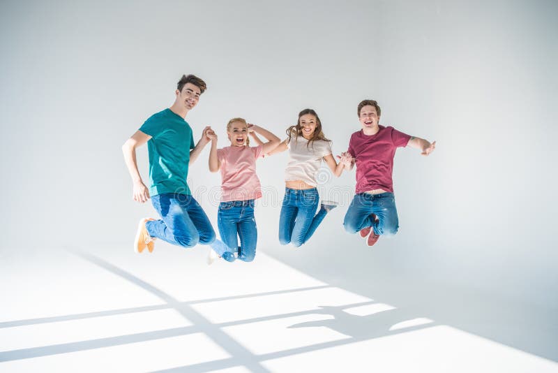 Young Friends Jumping Together Stock Image - Image of casual, pretty ...