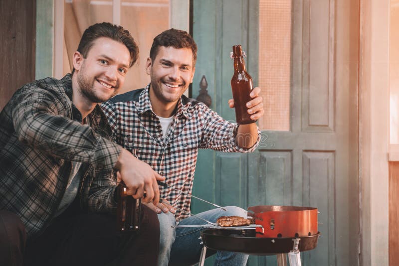Young Friends Making Barbecue and Drinking Beer on Porch with Back ...