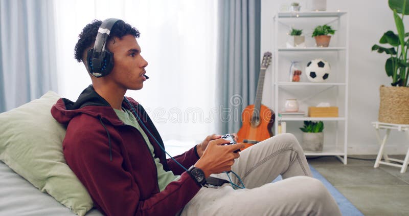 A Young Gamer Playing a Console Video Game and Talking on a Wireless ...