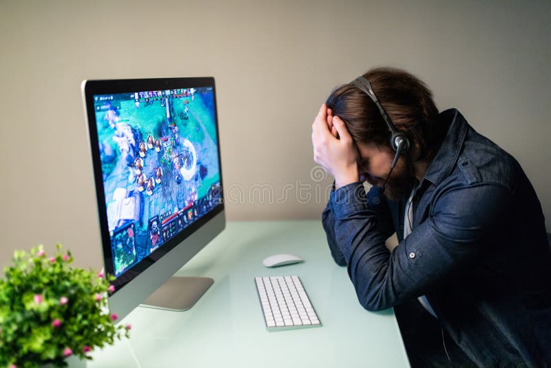 Young Upset Gamer Playing Online Video Games on Computer and Feel ...
