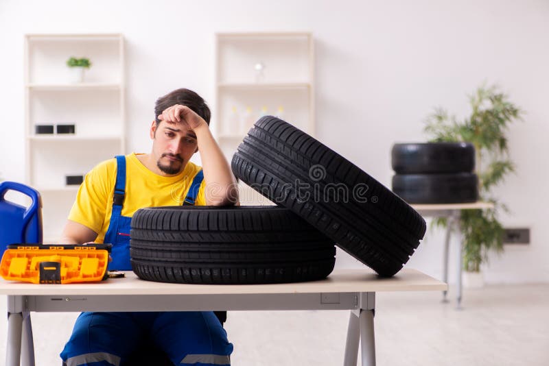 Young Male Garage Worker with Tyre at Workshop Stock Image - Image of ...