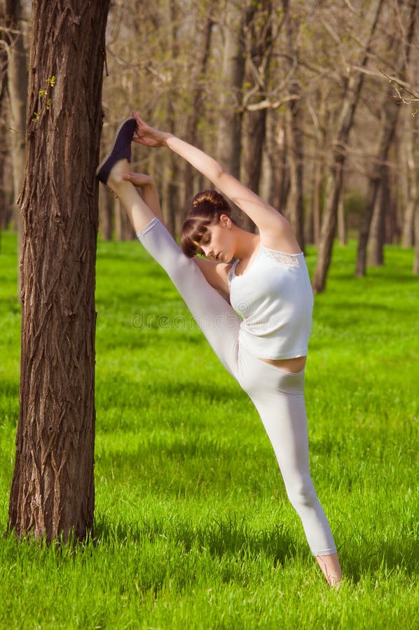 Young Girl Athlete Doing Stretching in a Tree on the Grass Stock Image ...