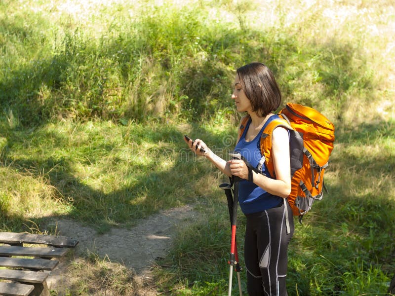A Young Girl with a Backpack Use the Phone. Stock Image - Image of ...