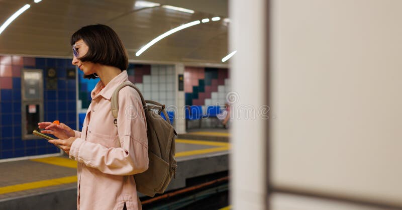 Young Girl with a Backpack Uses a Smartphone in the Subway. Girl ...