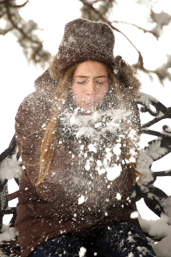 A Young Girl Blowing Snow Out of Her Mittens. Stock Image - Image of ...
