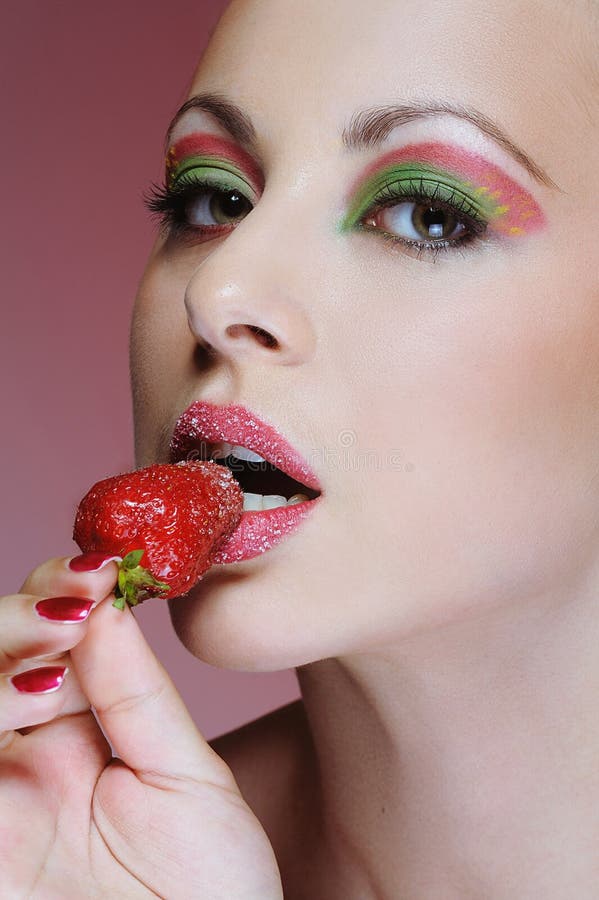 Young Girl with Bright Makeup Eating Strawberry Stock Photo - Image of ...