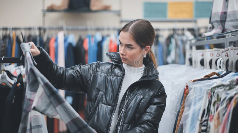 A Young Girl Choosing and Looking at Clothes in the Store. Stock Photo ...