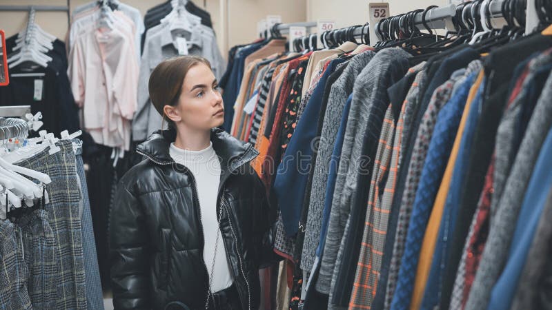 A Young Girl Choosing and Looking at Clothes in the Store. Stock Photo ...