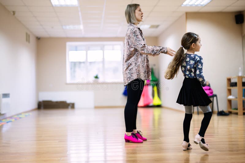 Young Girl in Dance Class with Instructor Helping with Hair in Studio ...