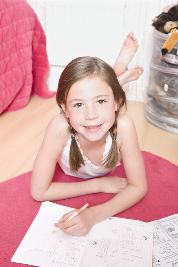 Young Girl Doing Homework on Floor Stock Image - Image of girl, lying ...