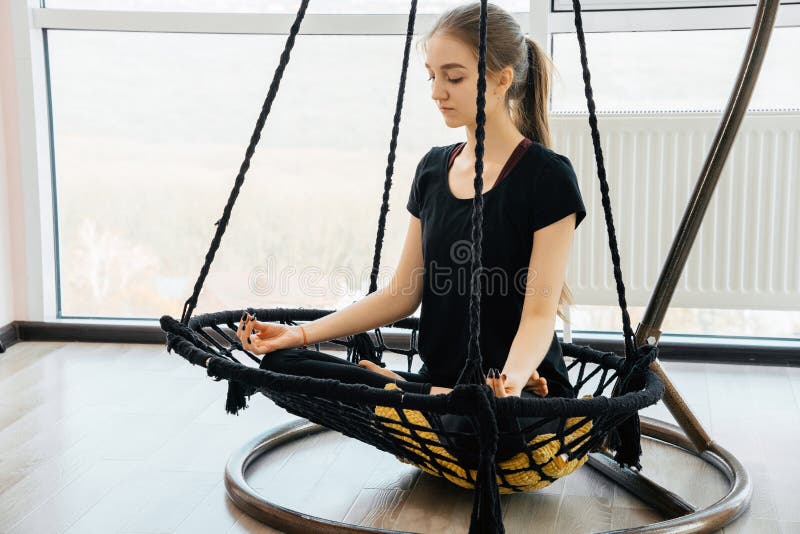 Young Girl Doing Yoga Pose Sitting on a Swing in Yoga Class Stock Photo ...