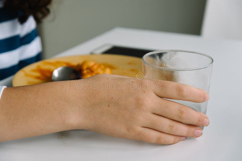 Young Girl Drinking Water and Eating at Home with Smartphone on Stock ...