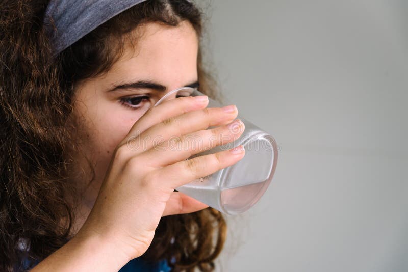 Young Girl Drinking Water and Eating at Home with Smartphone on Stock ...