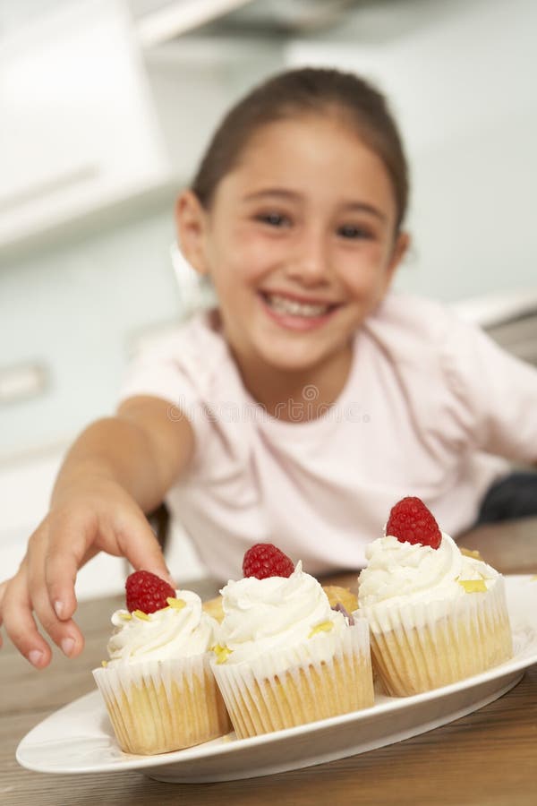 Young Girl Eating Cakes in Kitchen Stock Image - Image of person, happy ...