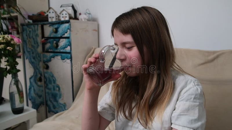 Young Girl Enjoying Refreshing Drink on Cozy Sofa in Relaxed Home ...