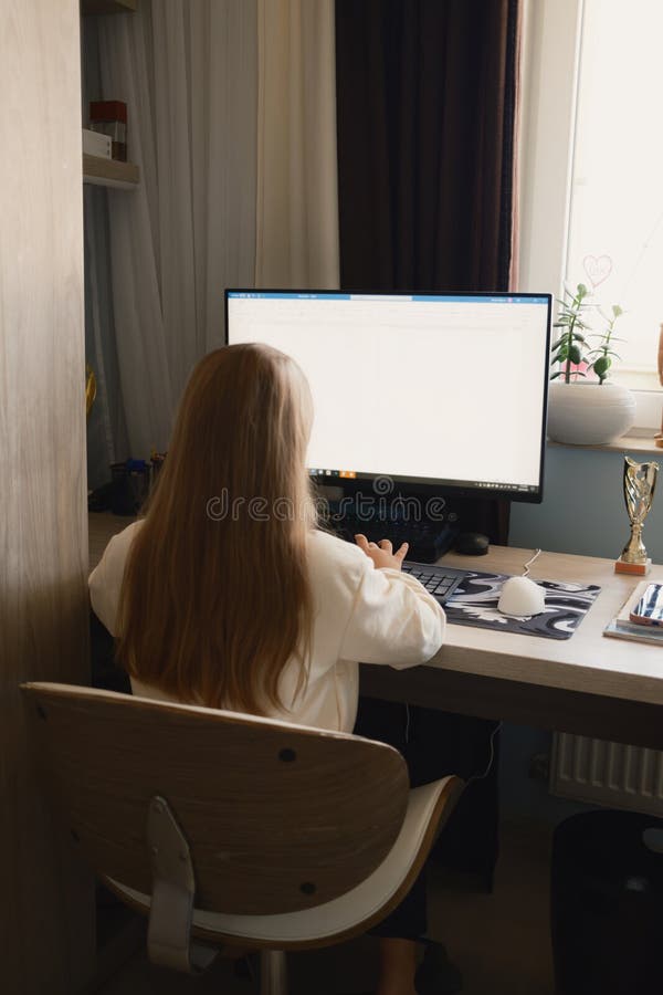 Young Girl Focusing on Work while Using a Computer in a Cozy Room Stock ...
